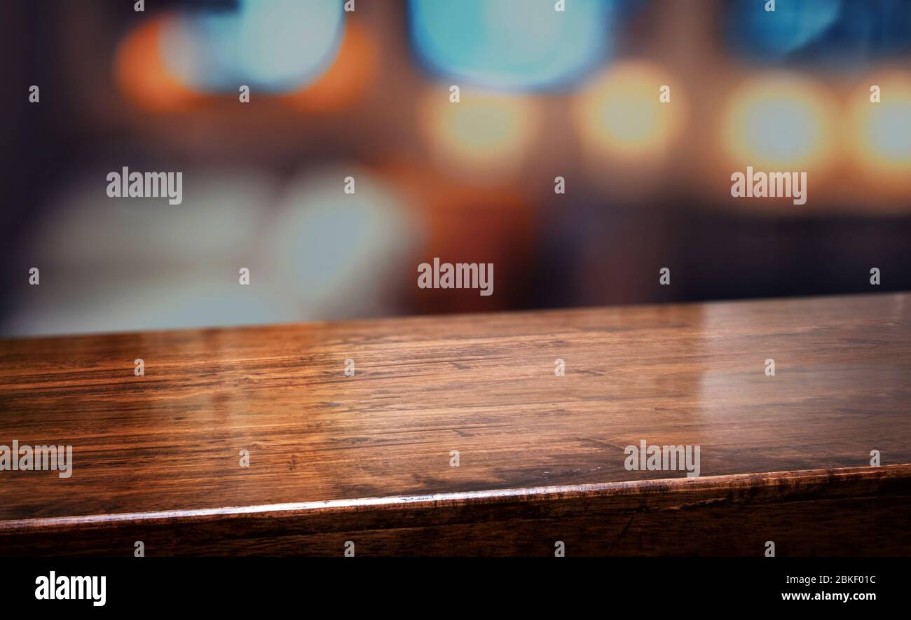 nightclub background.Empty diagonal brown wooden table with blur bar ...