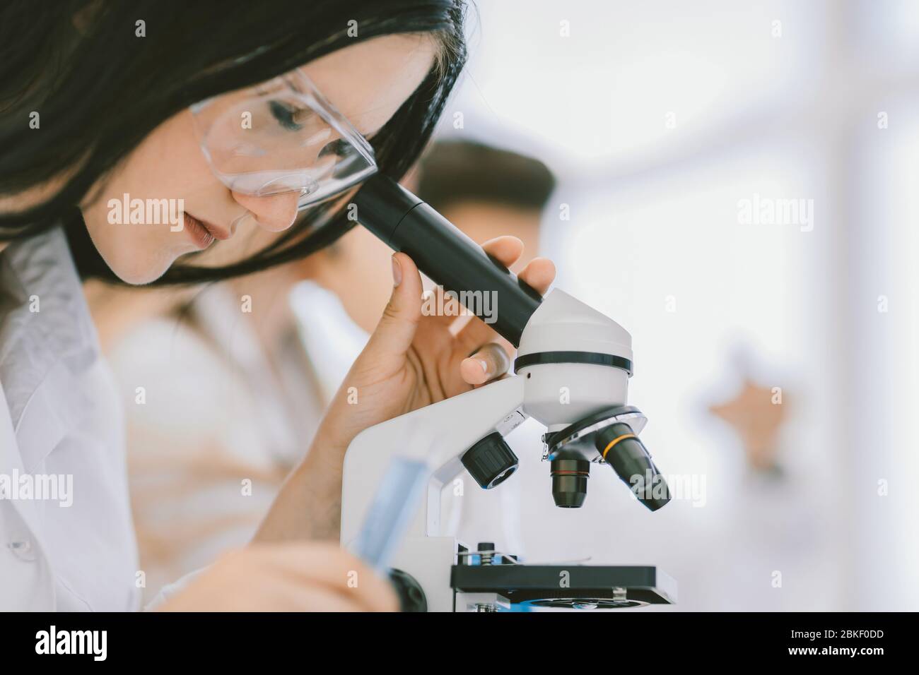 close up.the scientist looks into the microscope in the laborat Stock ...