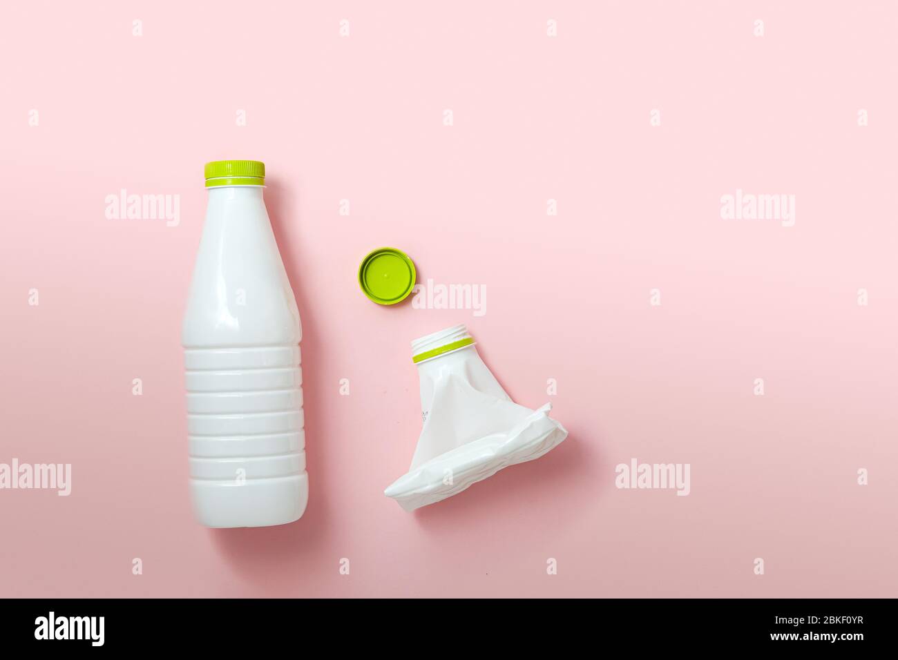 white plastic bottles on a pink background. the problem of waste ...