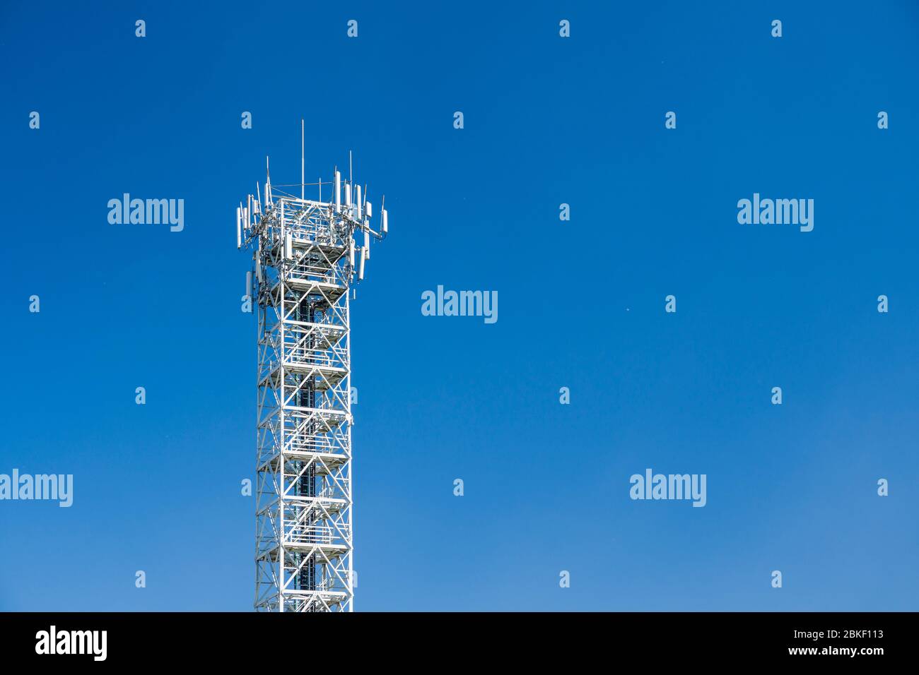 Telecommunication tower with antennas on blue sky. 4G and 5G cellular site base station ...