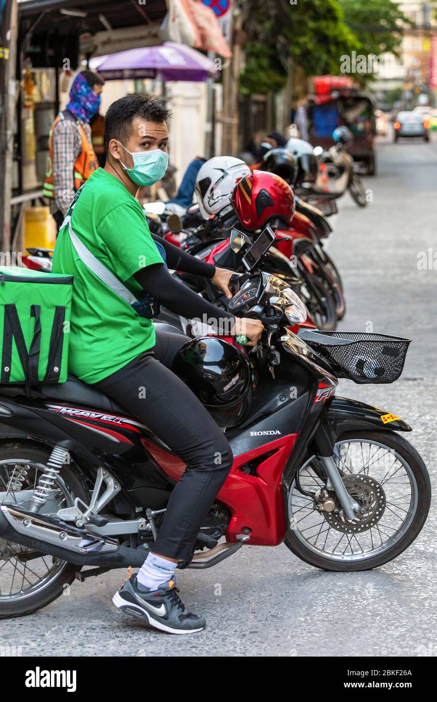 Grab food delivery driver with motorcycle, face mask and mobile phone ...