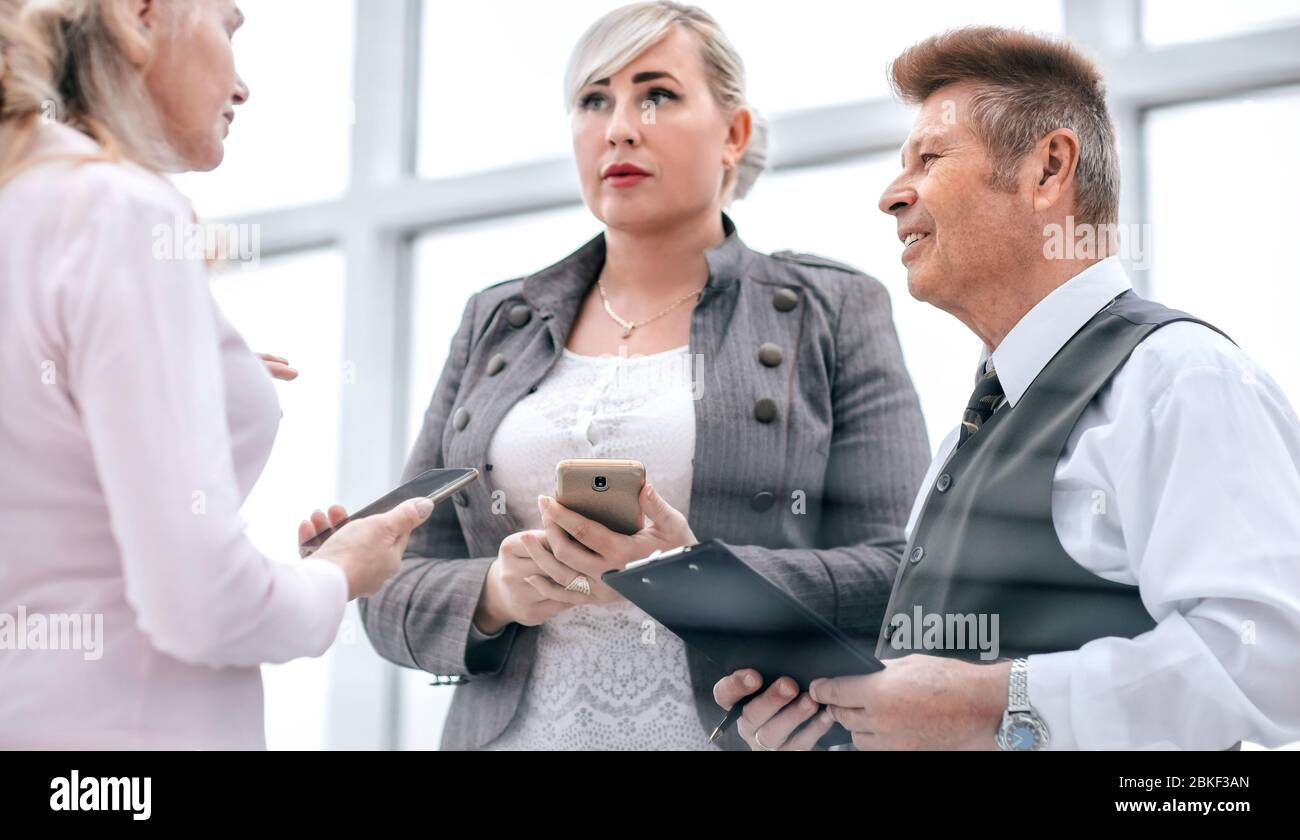 close up. a group of employees communicate in the workplace Stock Photo ...