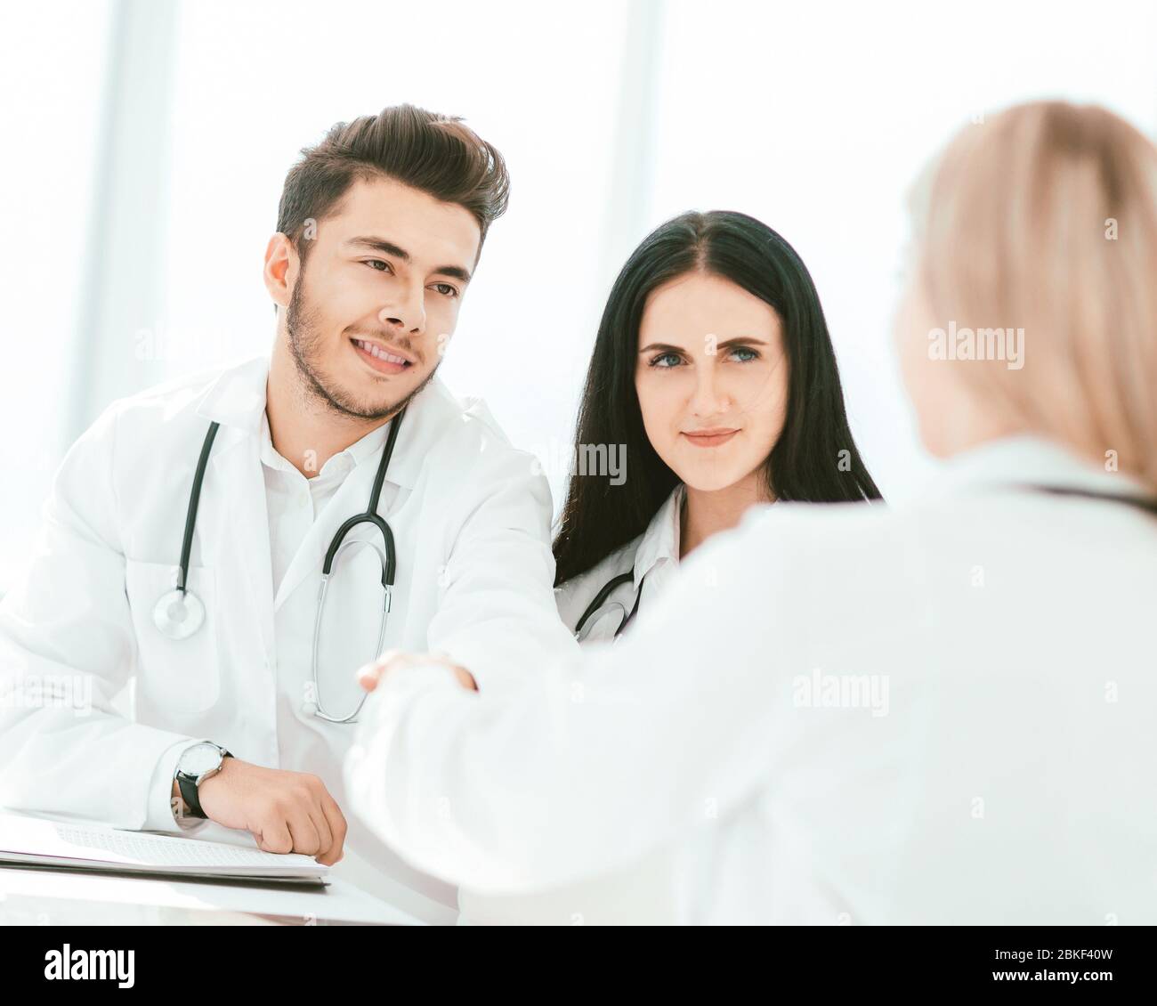 handshake of medical doctors at the Desk Stock Photo - Alamy