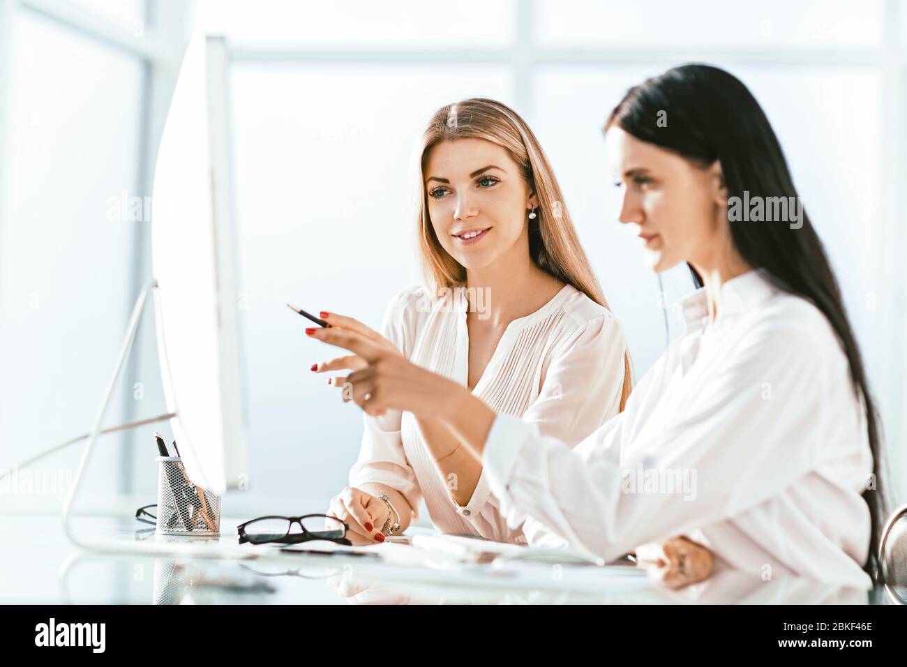 two employees are discussing something sitting at the office ta Stock ...