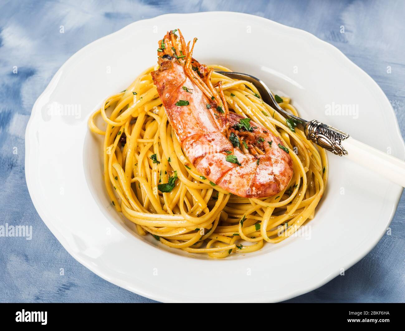 Linguine pasta with tiger prawn sauce in white dish Stock Photo - Alamy