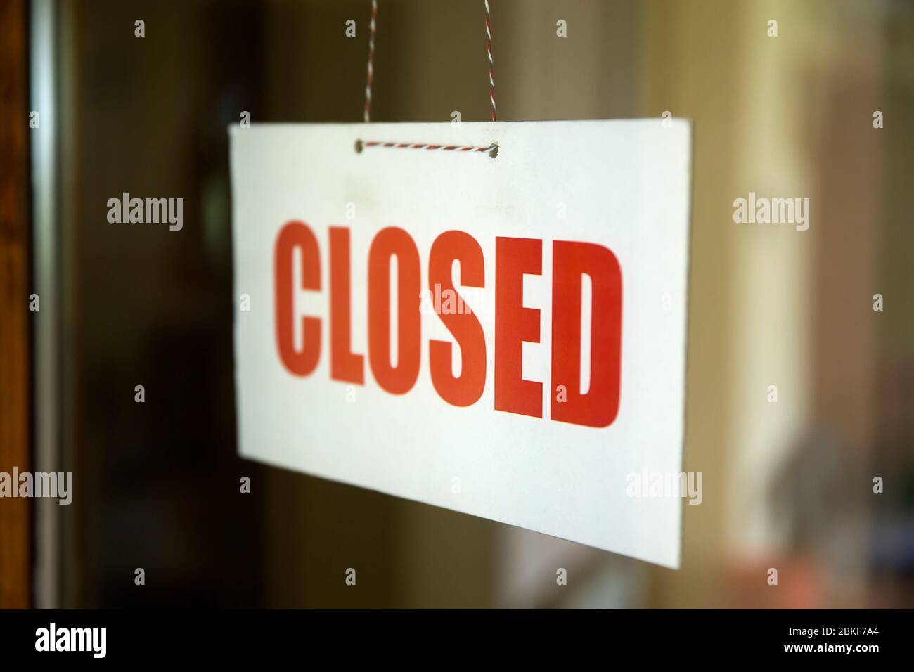 Closed sign board hanging on the glass door of cafe or small store ...
