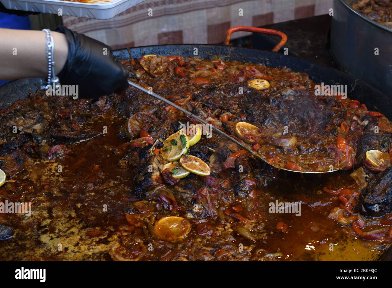 Traditional fish stew being prepared in a rustic bowl over a wood ...