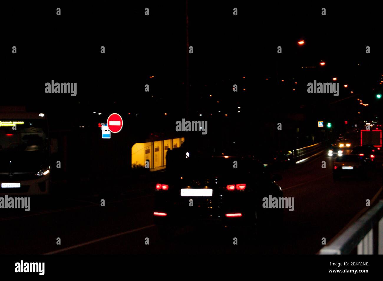 The lights of the night city are a narrow two-lane road with busy ...