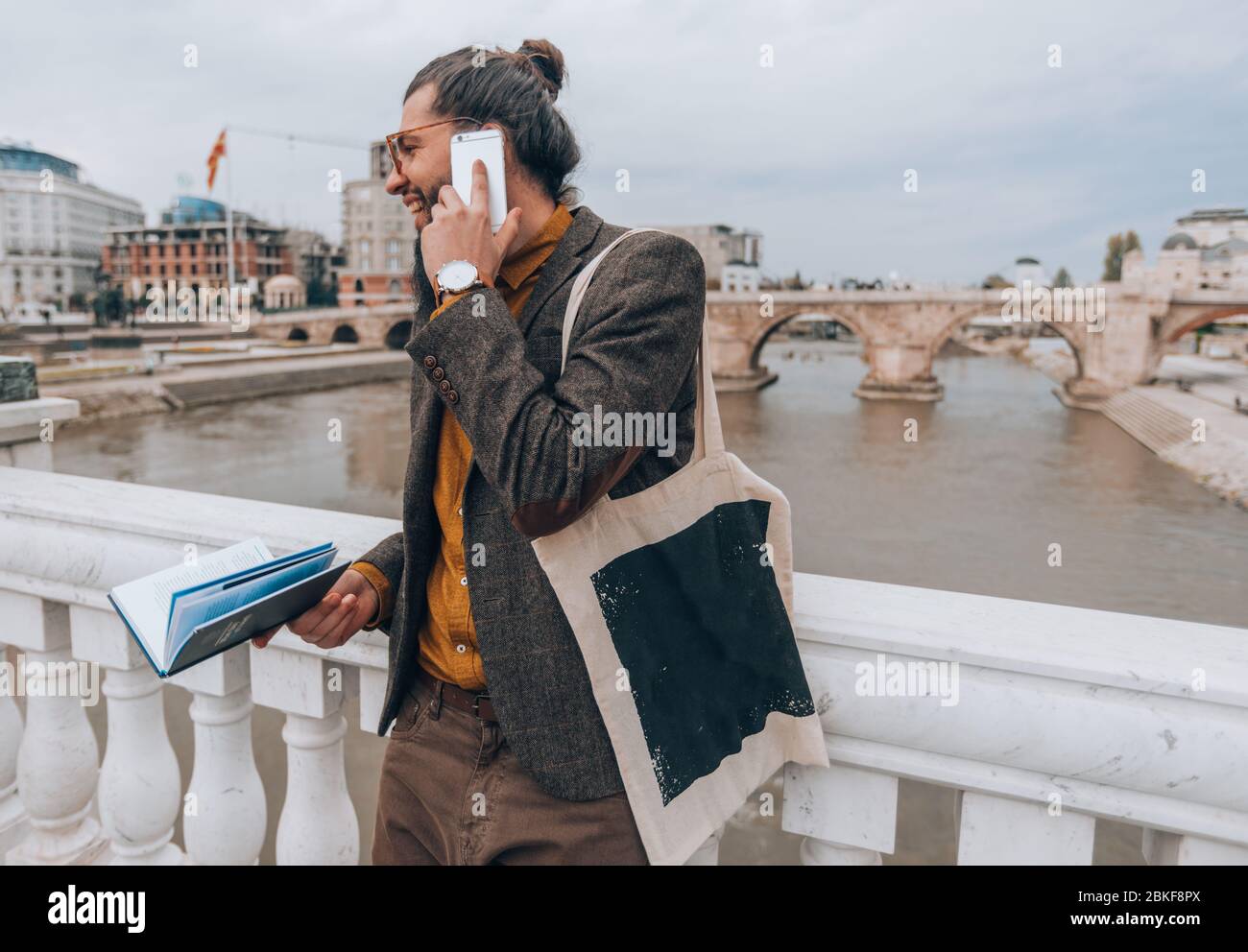 Modern day hipster making a business phone call at the city river Stock ...
