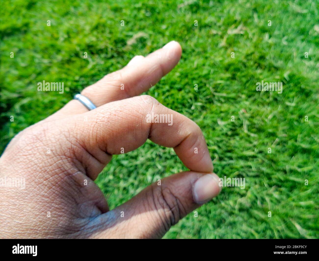 Hand making Fantastic symbol against a green grass background Stock ...