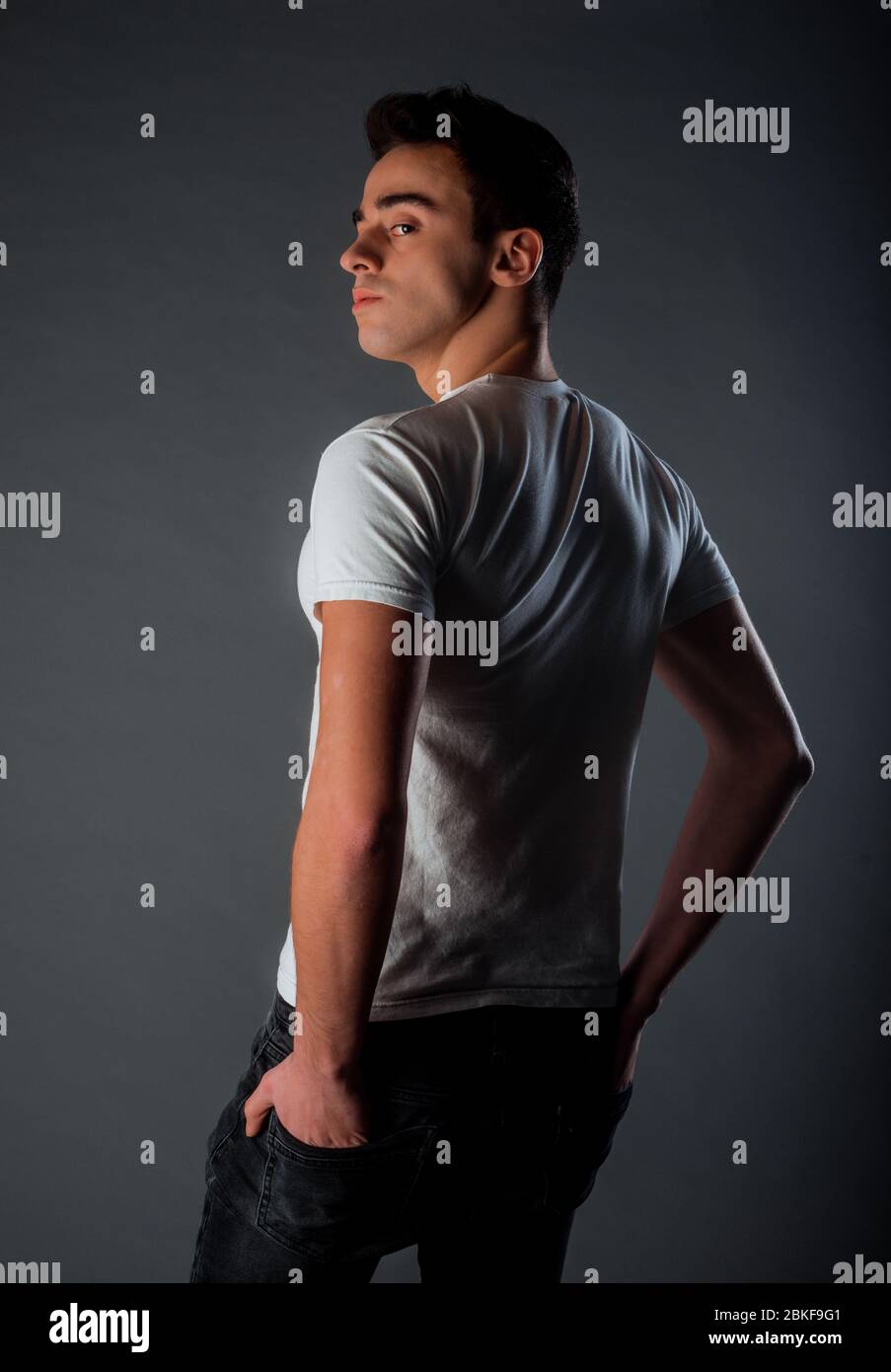 Cool handsome trendy guy wearing stylish white t-shirt looking over his ...