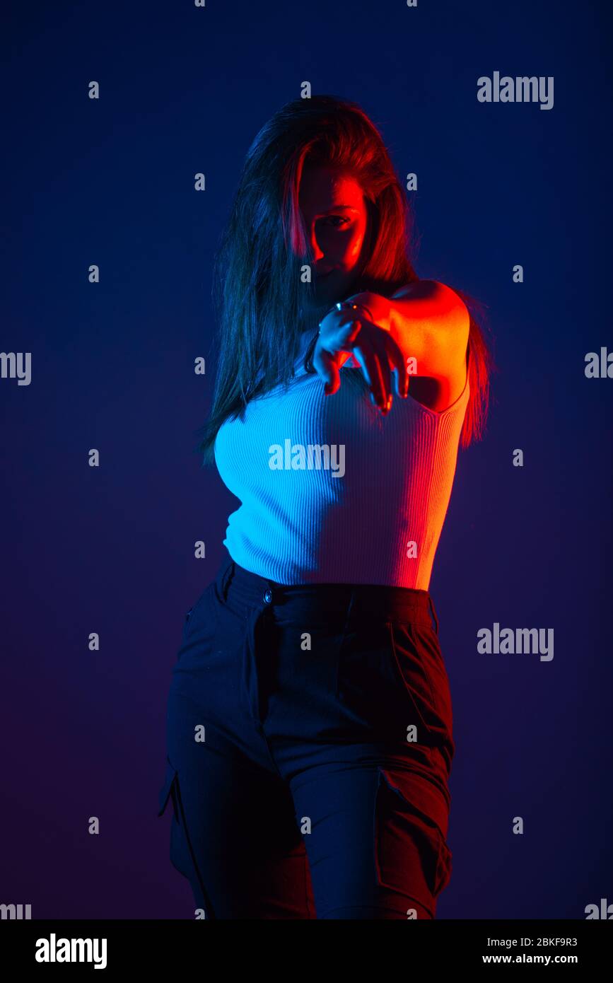 Female model posing in studio with red and blue colors at high contrast ...