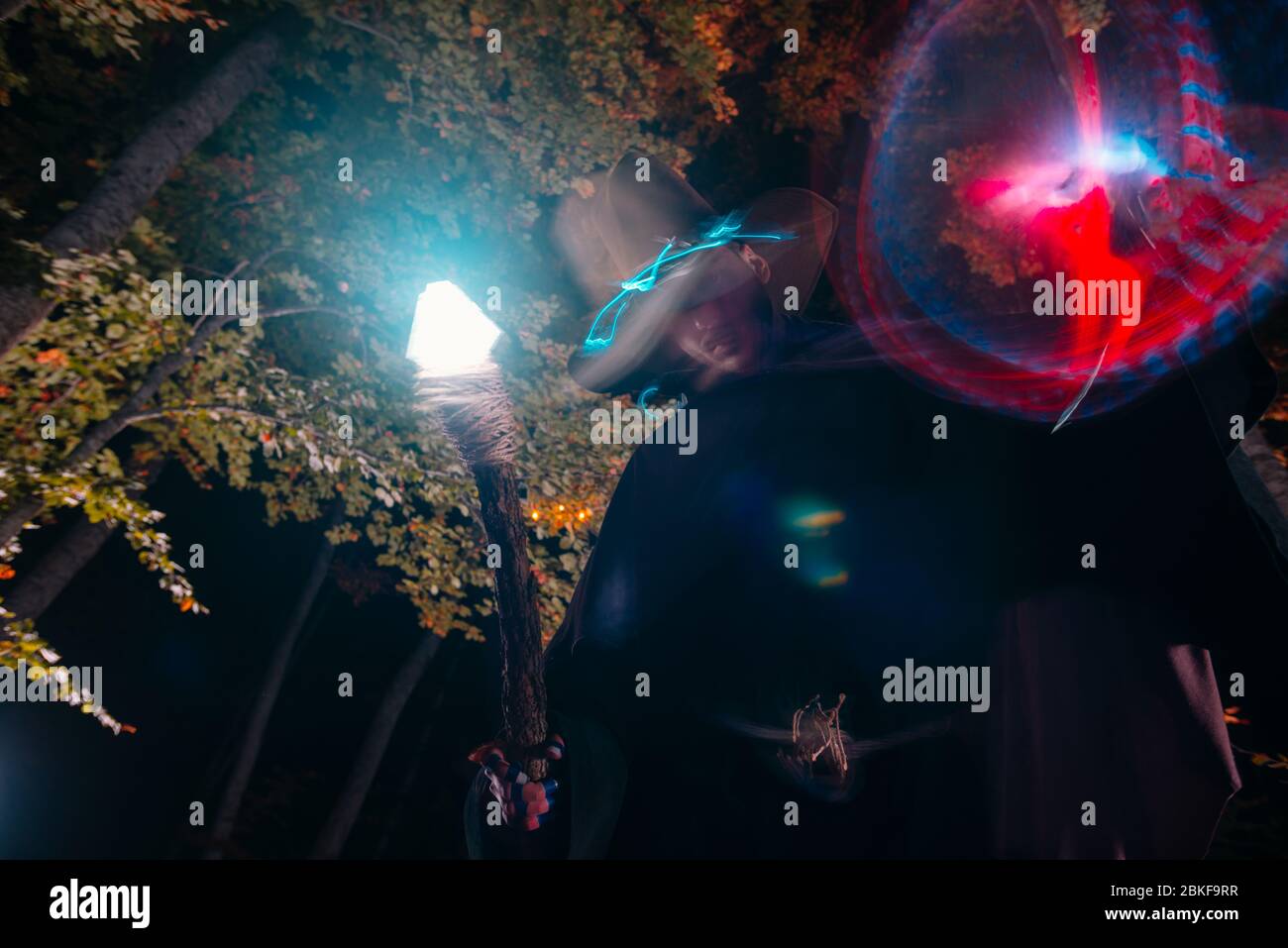 Wizard (mage) casting a spell with his magical staff while standing in ...