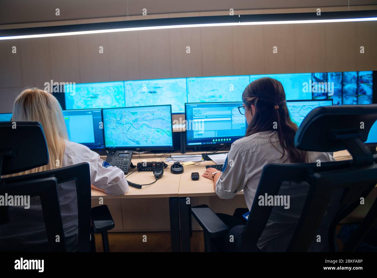 Female security guards working on computers while sitting in the main ...