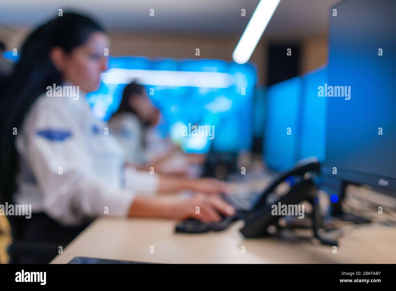 Blurred photo of security guards working on computers while sitting in ...