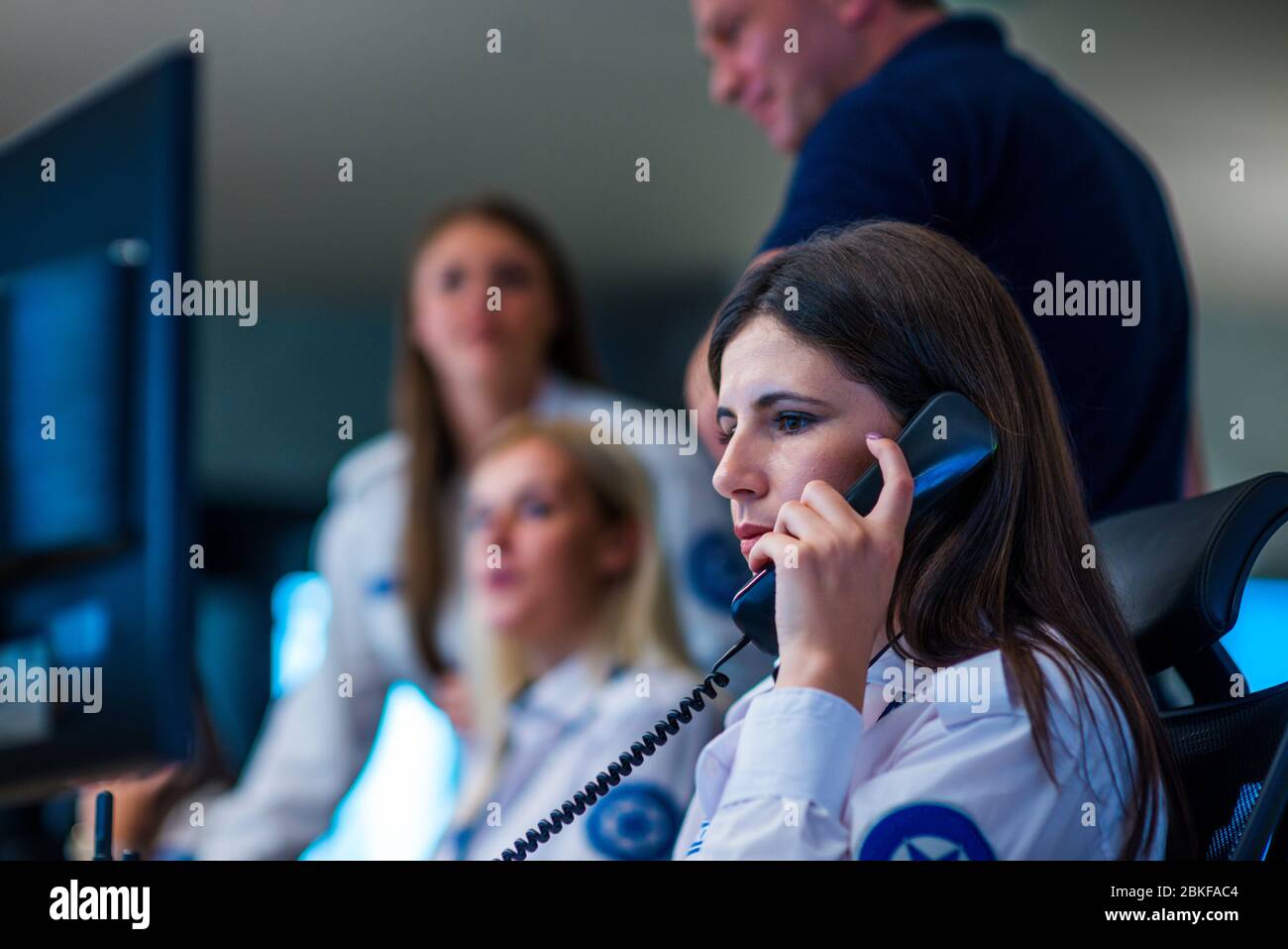 Security guards working in surveillance room. Female security guard ...