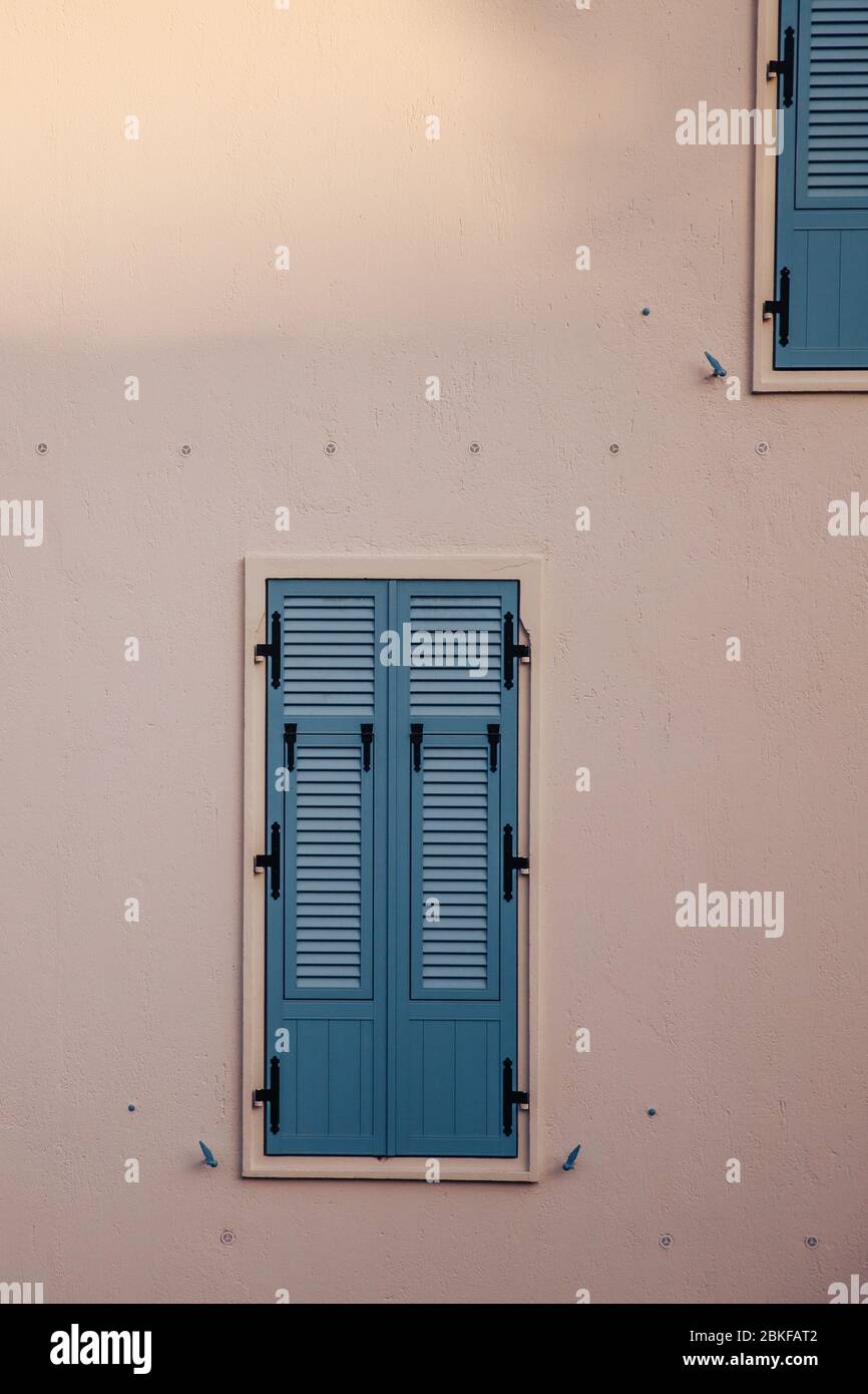 old European window with blue shutters on background of white walls ...