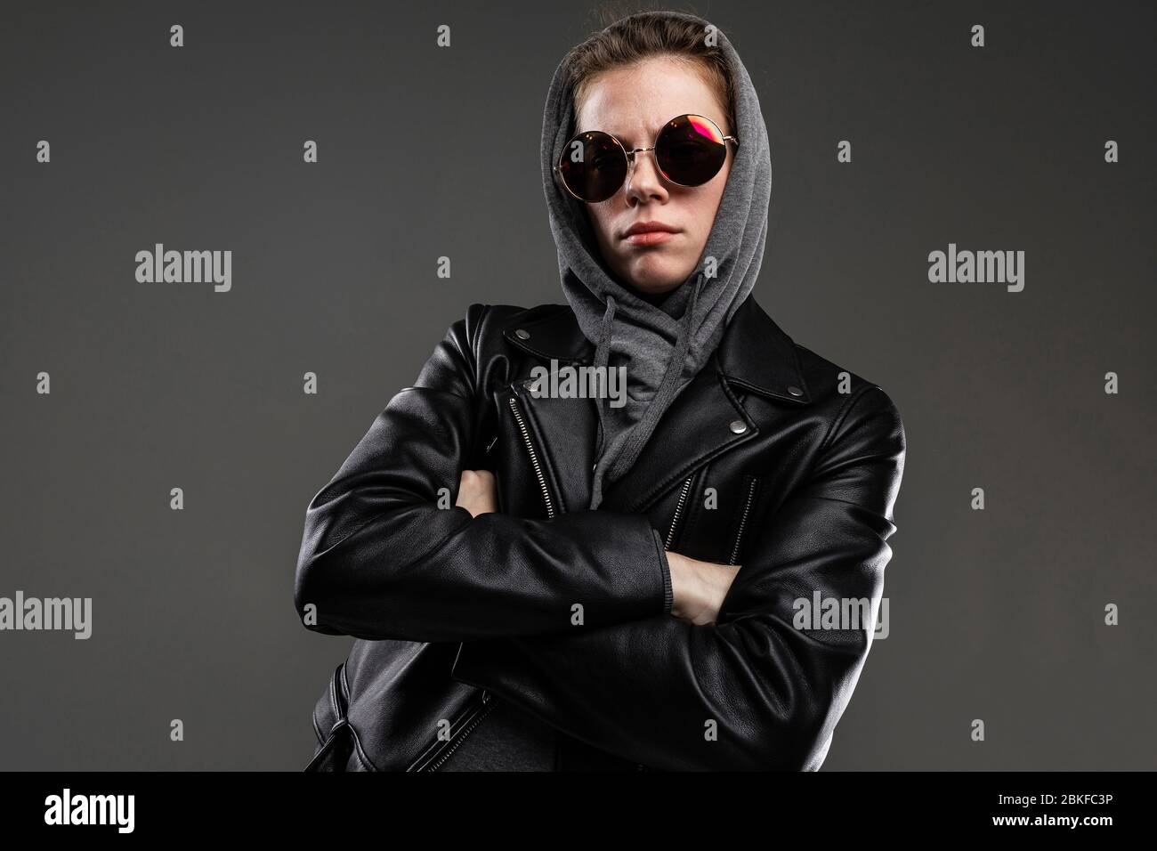 Brutal caucasian girl with rough facial features in a black jacket with ...