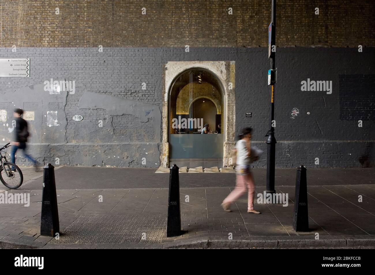 Streetscene showing a view into a restaurant through an arched window ...