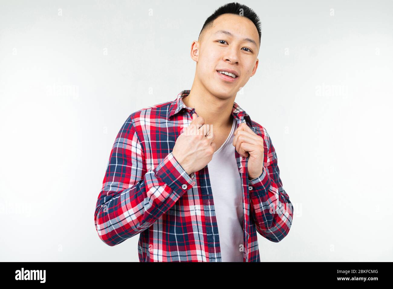 handsome asian man in a checkered shirt wide open isolated on a white ...