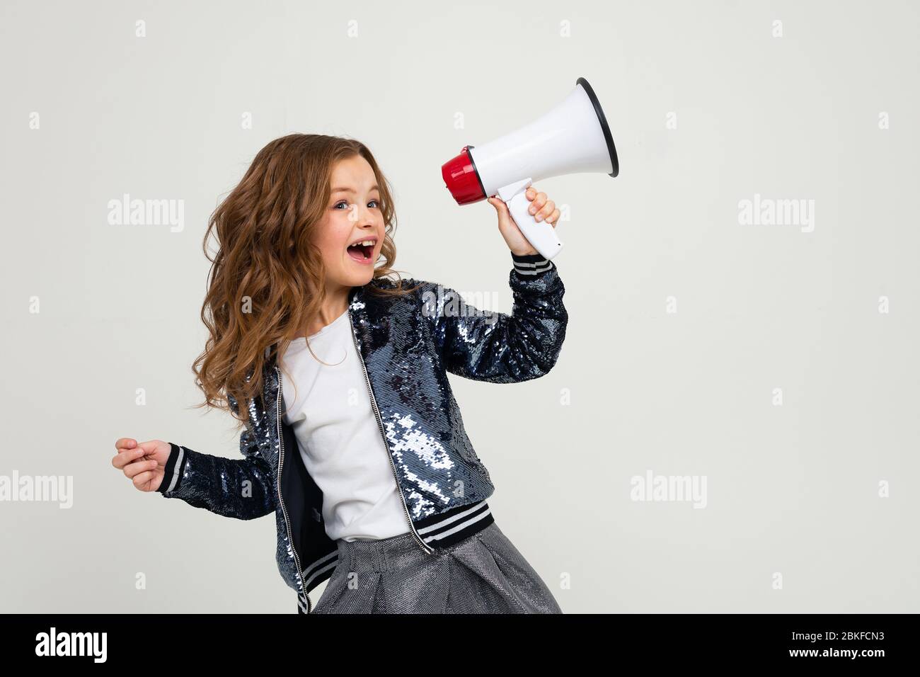 european cute teenager girl with a megaphone reports the news on a pure ...