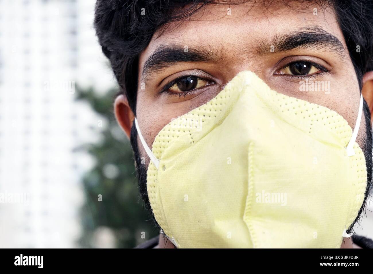 Indian man in yellow protective mask Stock Photo - Alamy