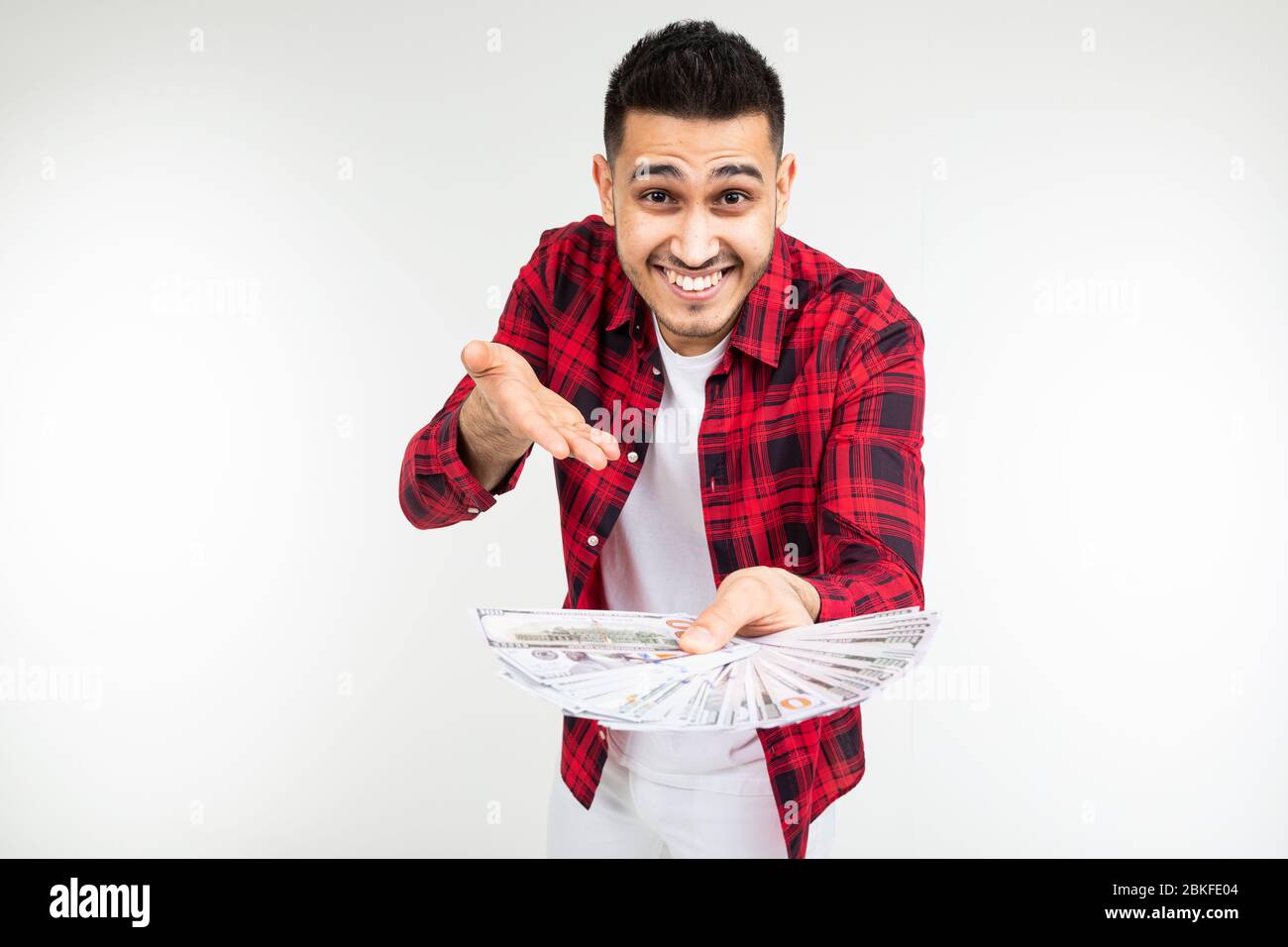 joyful man boasting a prize holding out money on a white background ...