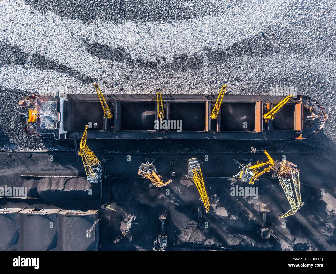 Loading coal mining in port on cargo tanker ship with crane bucket of ...