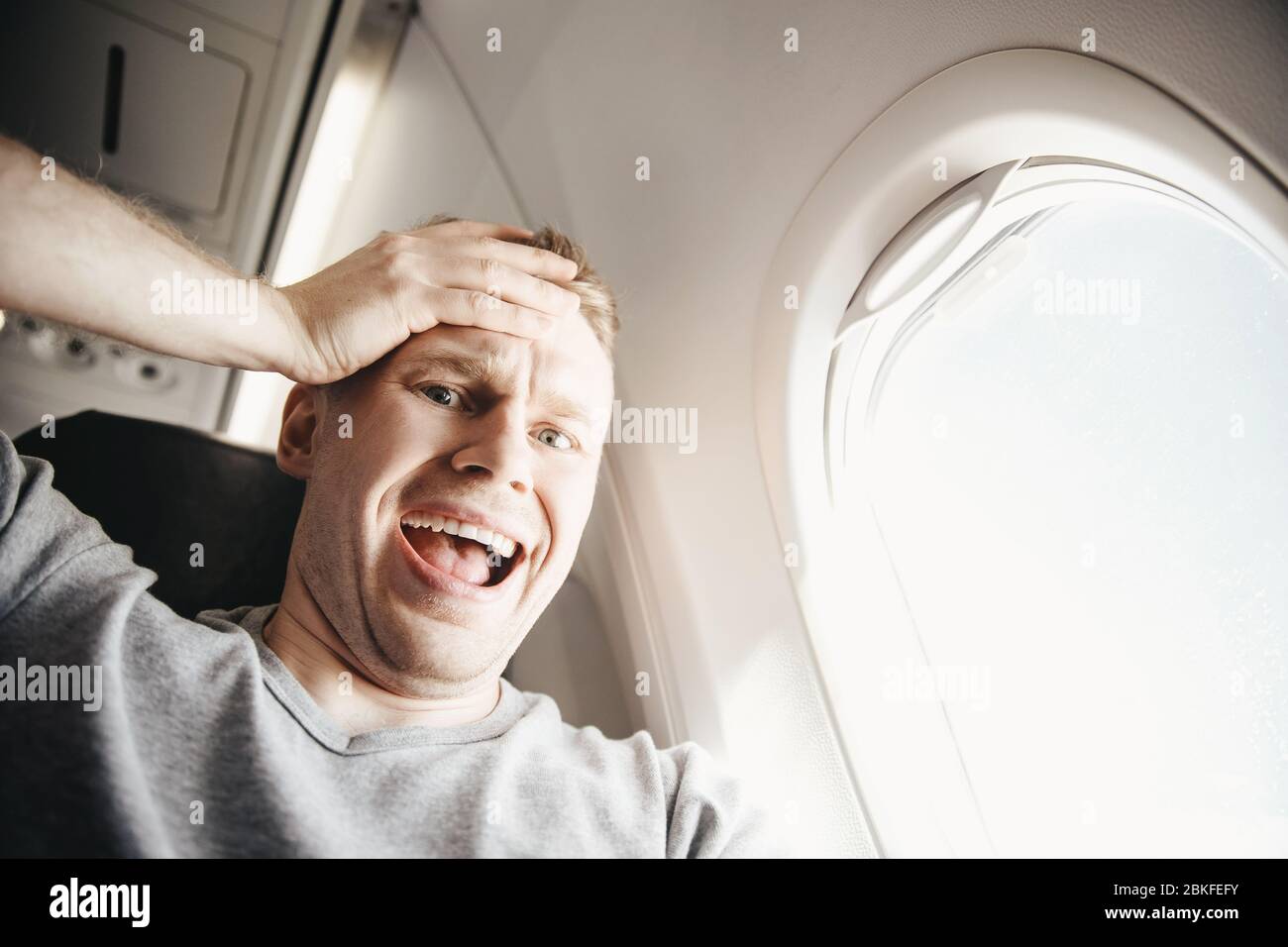 Male passenger in plane screams and cries, aerophobia. background of ...