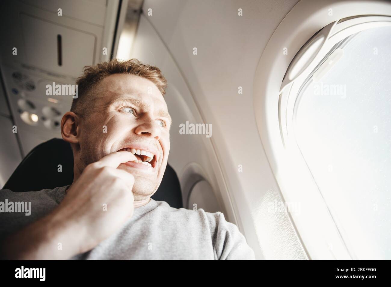 Male passenger in plane screams and cries, aerophobia. background of ...