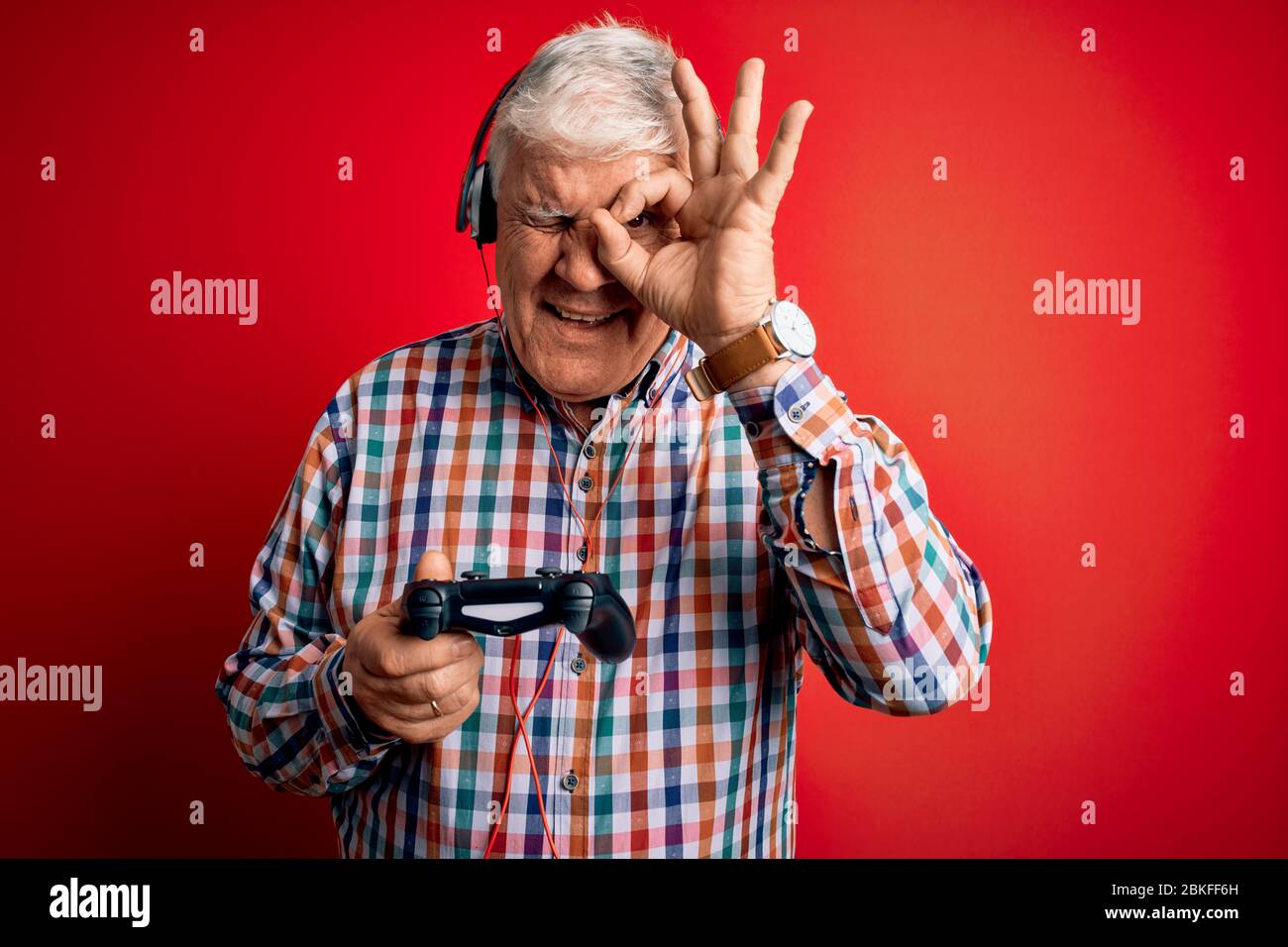 Senior handsome hoary gamer man playing video game using joystick and ...