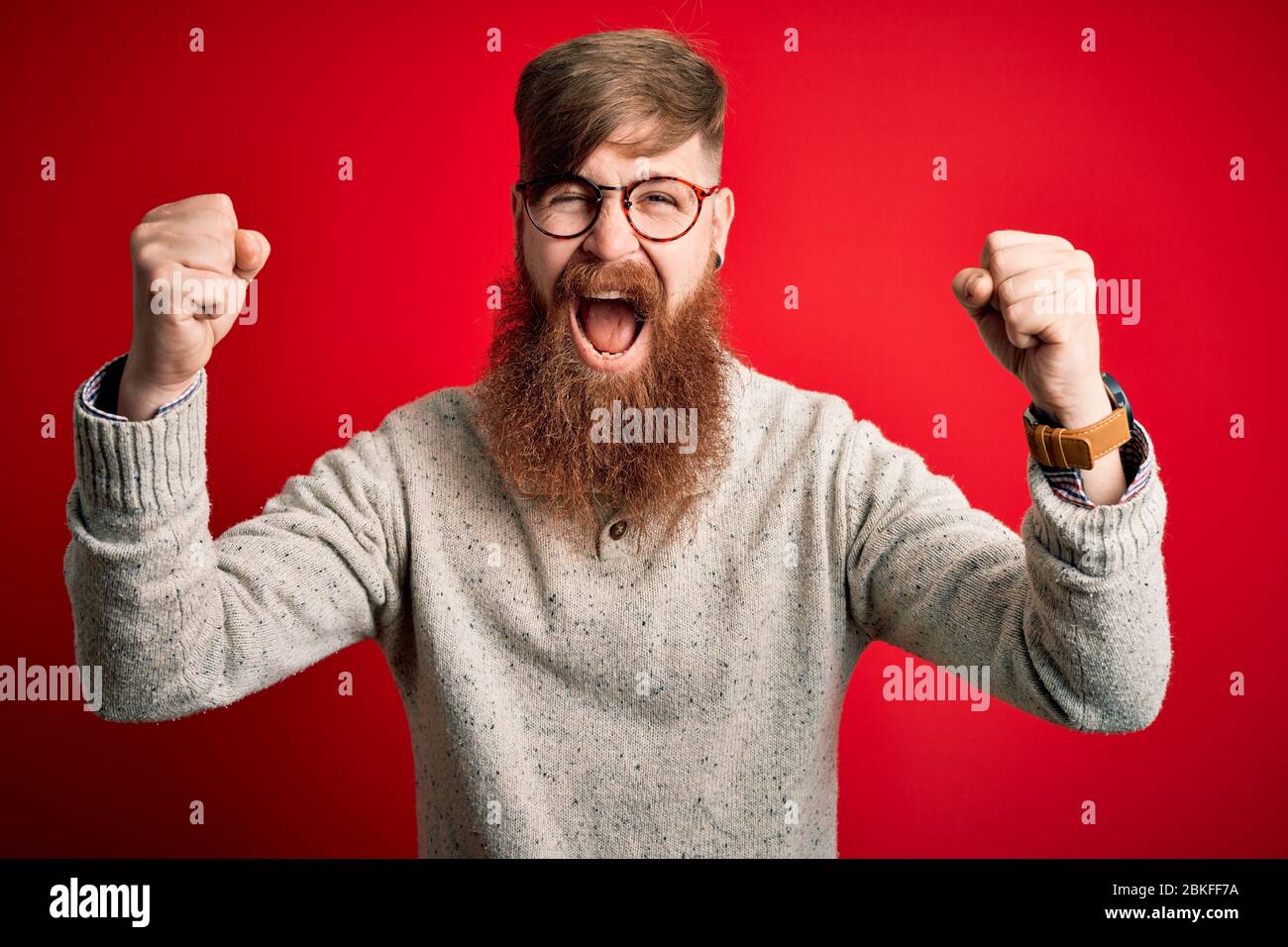 Handsome Irish redhead man with beard wearing casual sweater and ...
