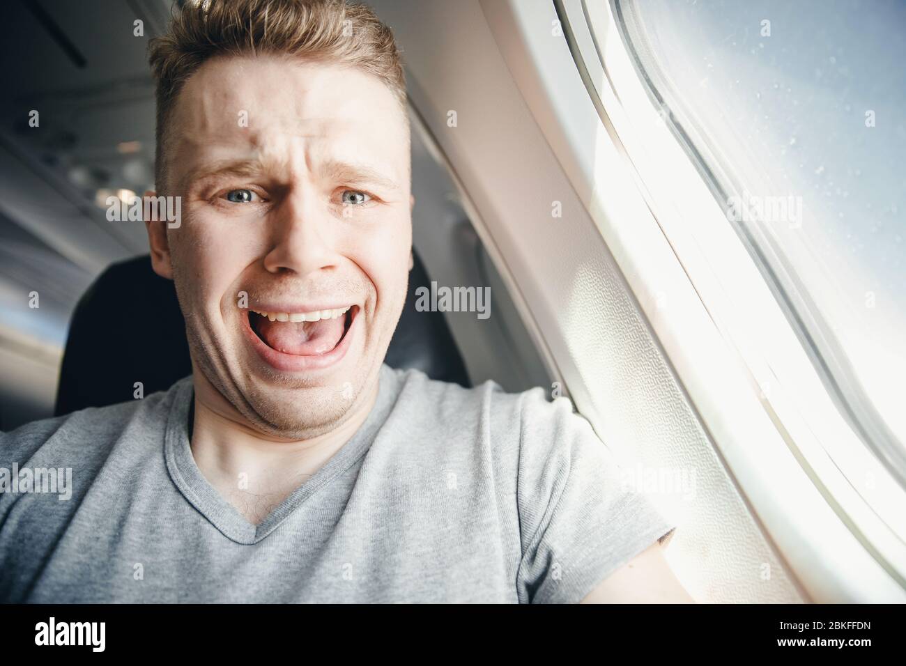 Male passenger in plane screams and cries, aerophobia. background of ...