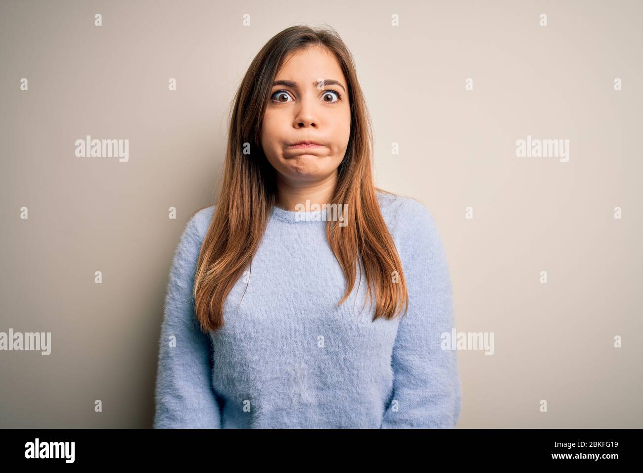 Beautiful young woman wearing casual winter sweater standing over ...