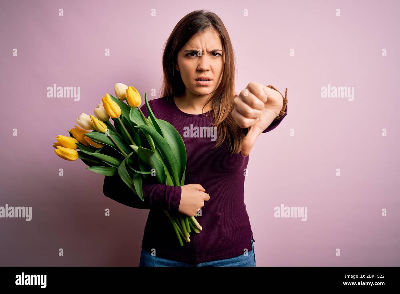 Young blonde woman holding romantic bouquet of yellow tulips flowers ...
