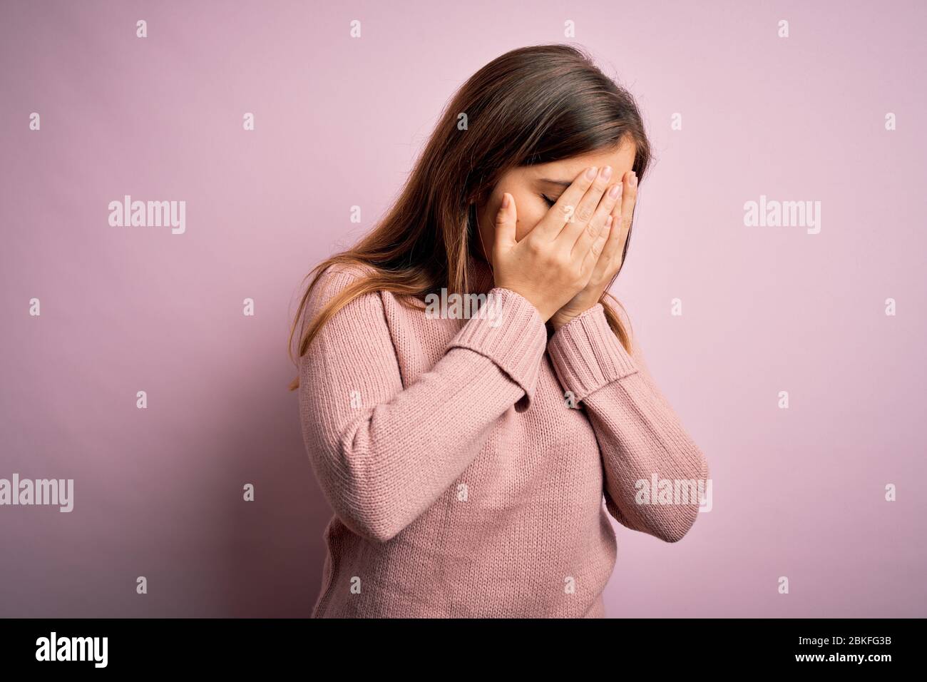 Beautiful young woman wearing turtleneck sweater over pink isolated ...