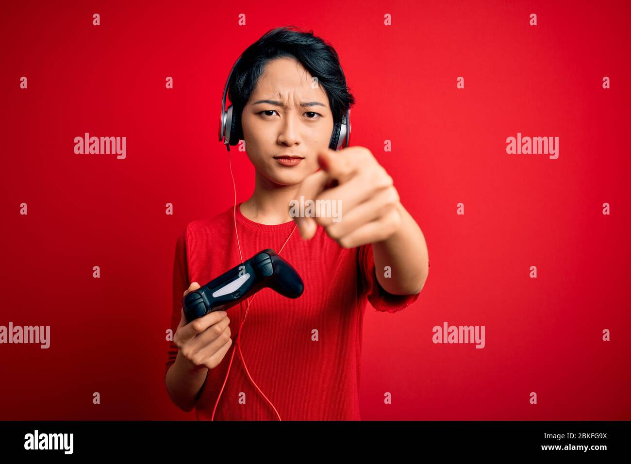 Young beautiful asian gamer girl playing video game using joystick and ...