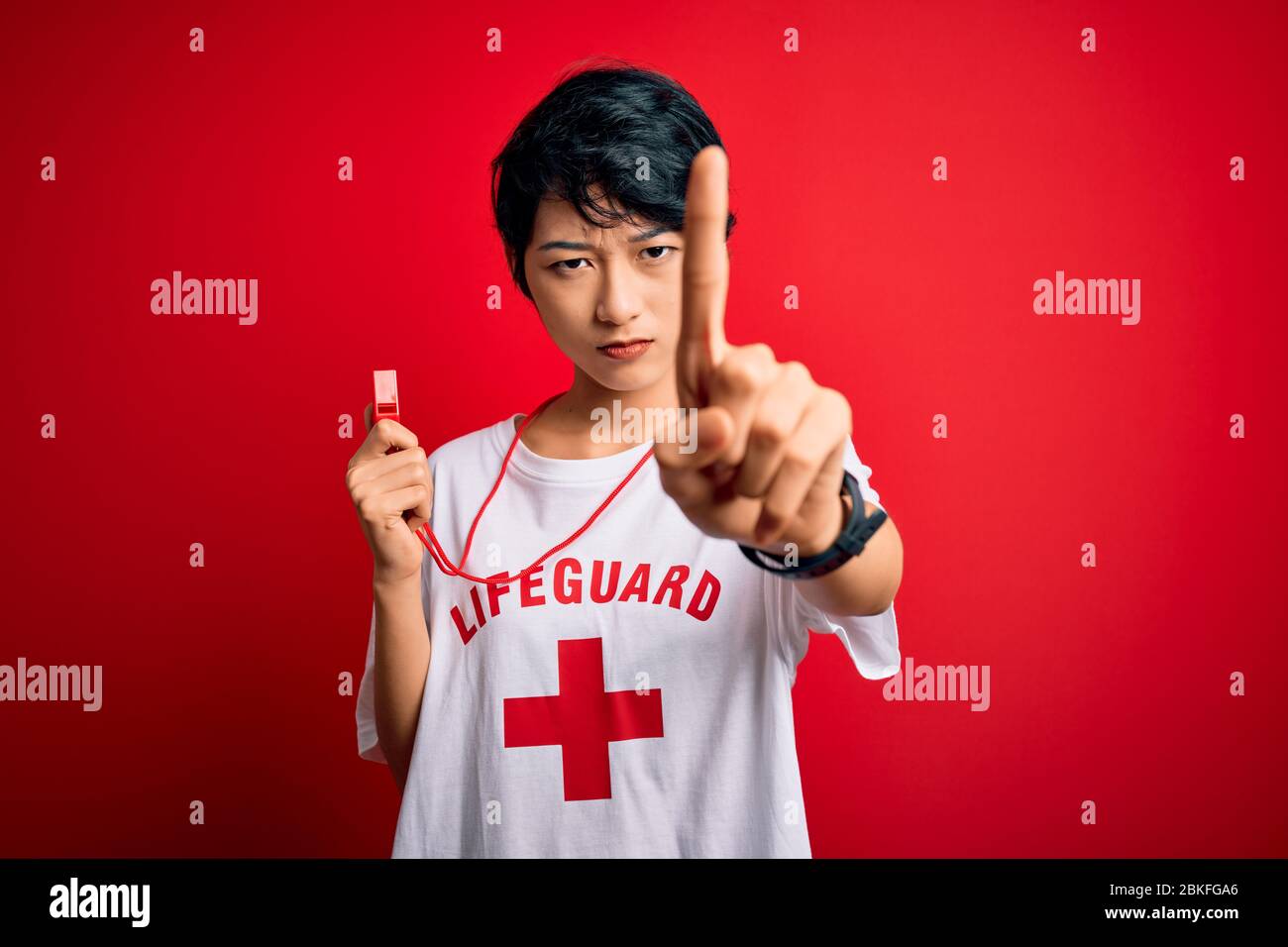 Young beautiful asian lifeguard girl wearing t-shirt with red cross ...