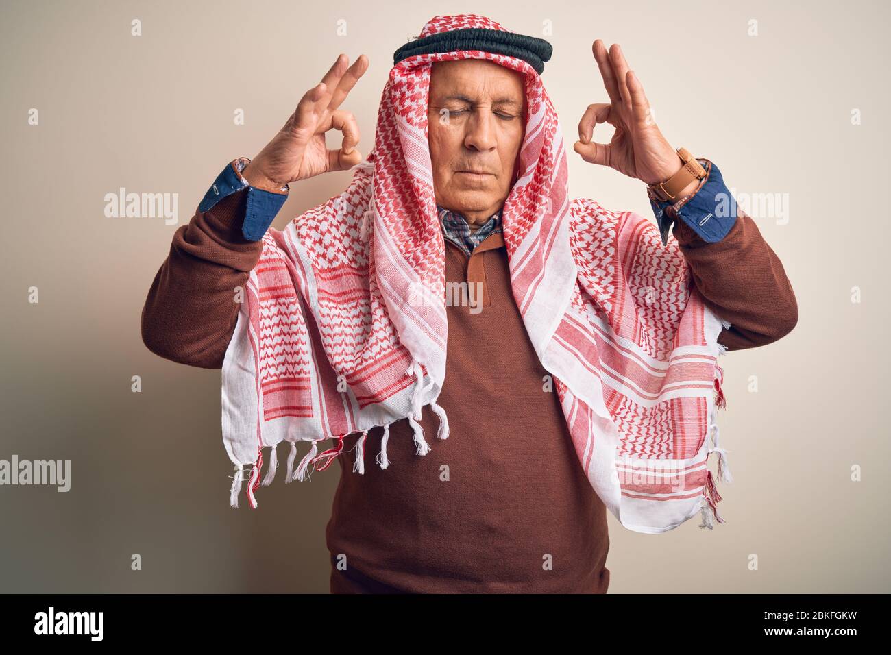 Senior handsome arab man wearing keffiyeh standing over isolated white ...