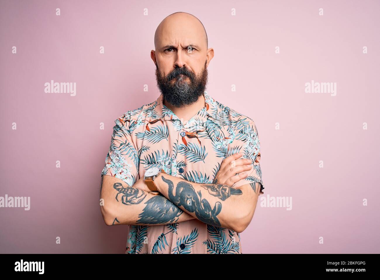 Handsome bald man with beard and tattoo wearing casual floral shirt ...