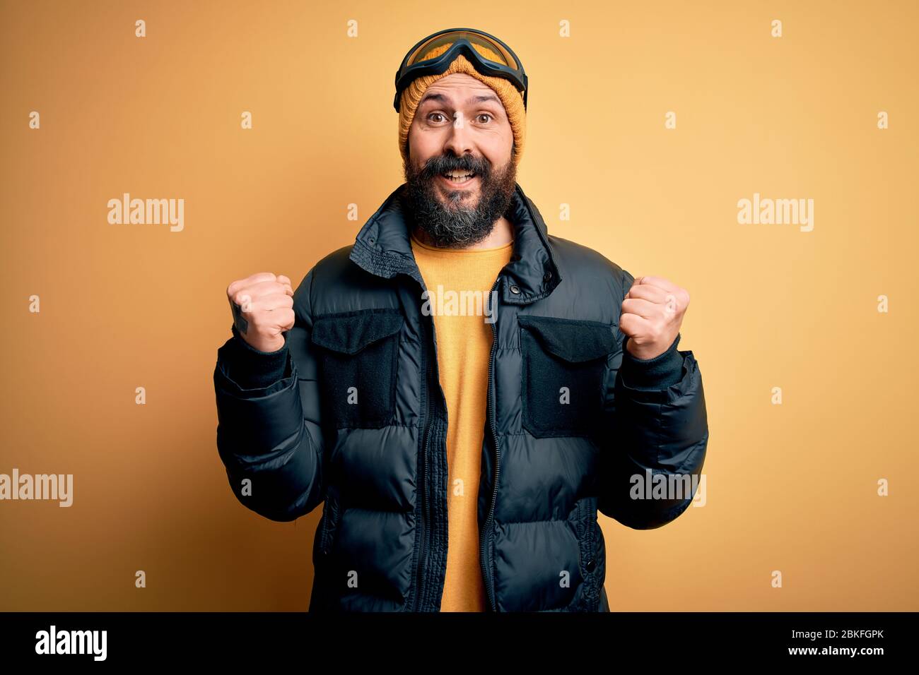 Handsome skier bald man with beard skiing wearing snow sportswear and ...