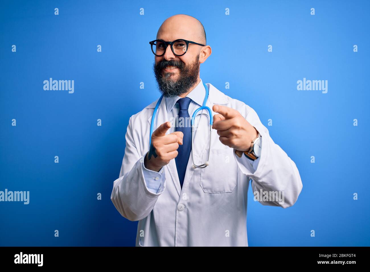 Handsome bald doctor man with beard wearing glasses and stethoscope ...