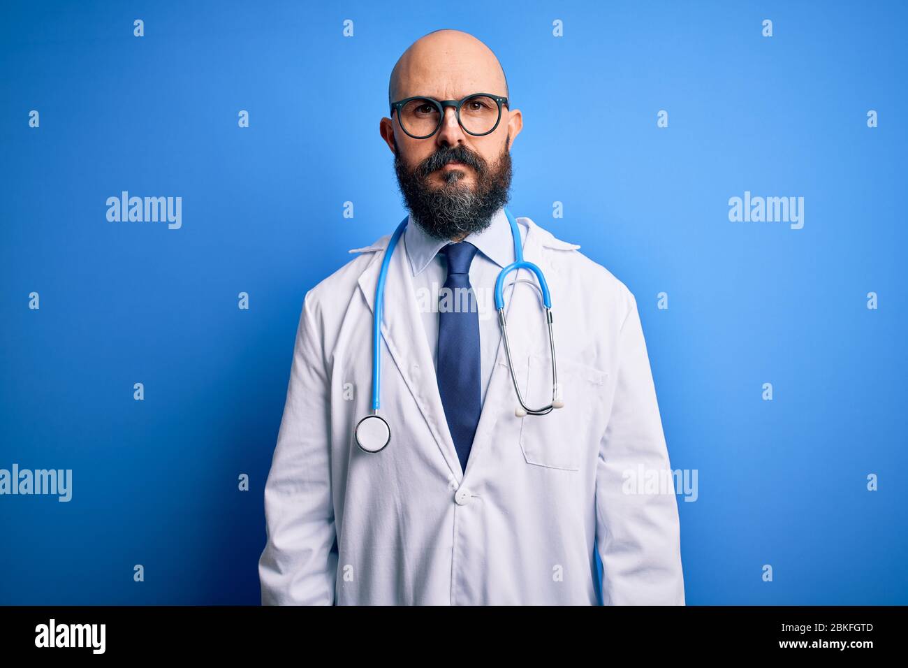 Handsome bald doctor man with beard wearing glasses and stethoscope ...