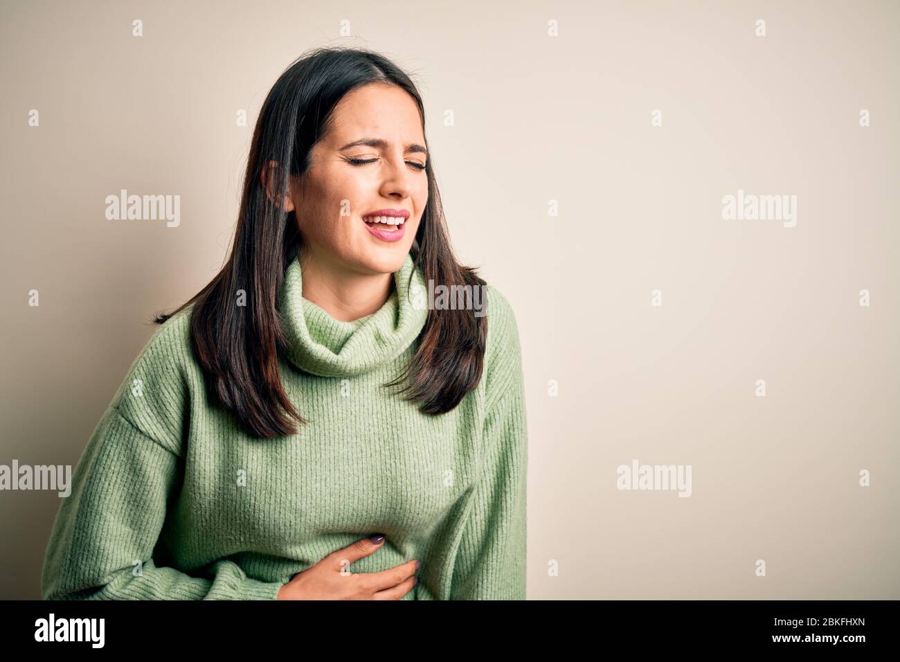 Young brunette woman with blue eyes wearing turtleneck sweater over ...