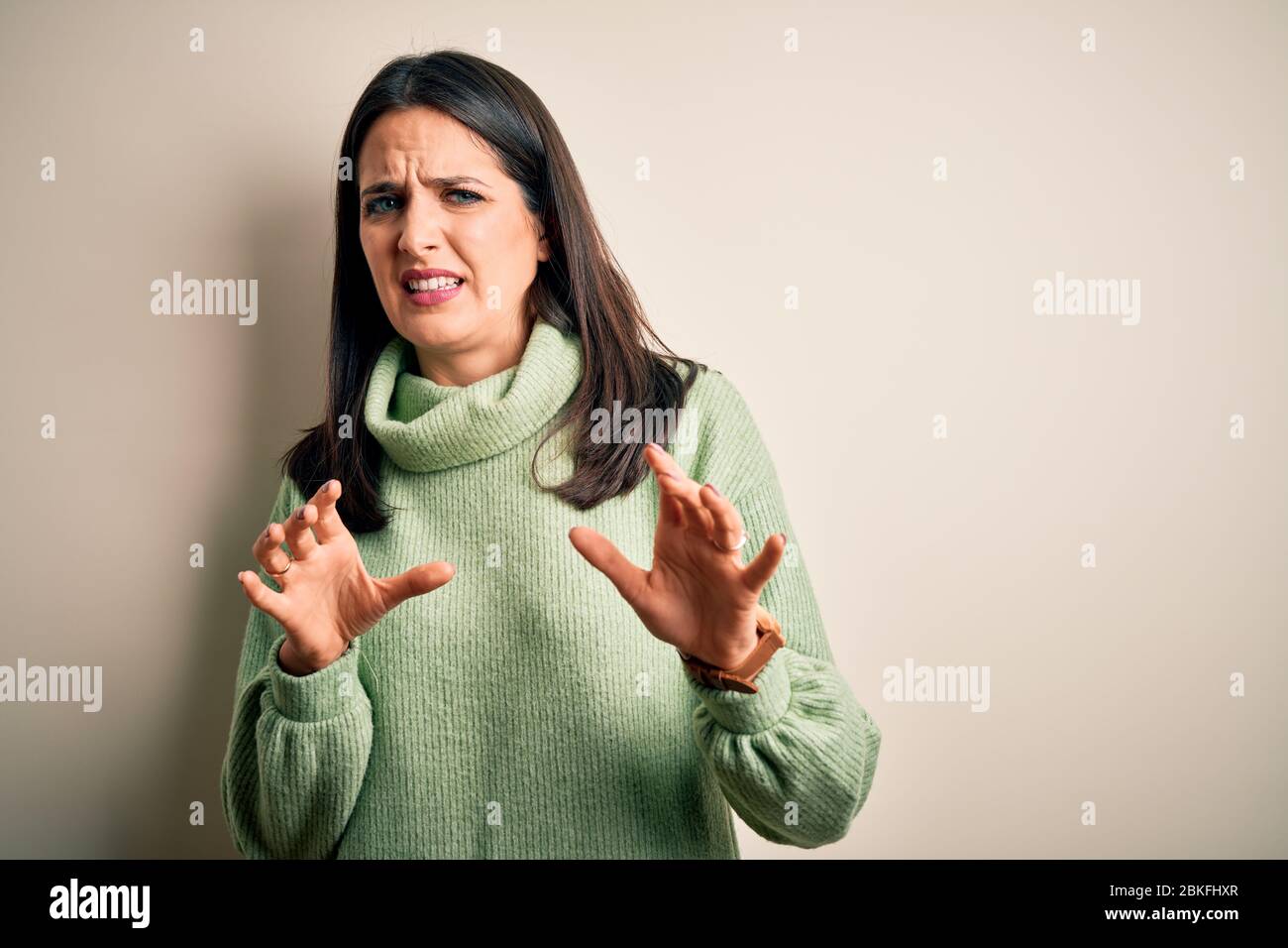 Young brunette woman with blue eyes wearing turtleneck sweater over ...