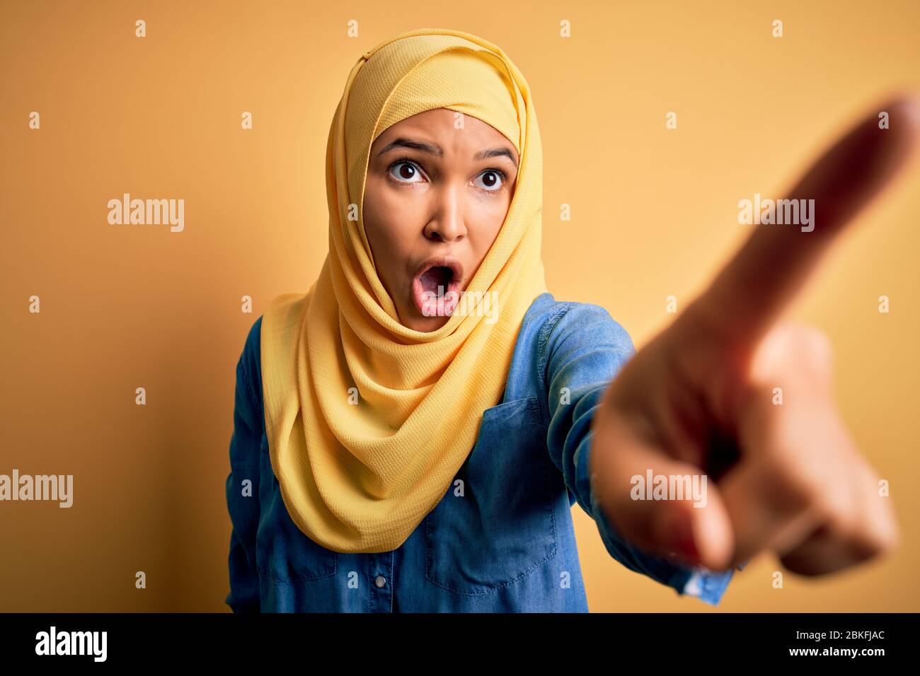 Young beautiful woman with curly hair wearing arab traditional hijab ...