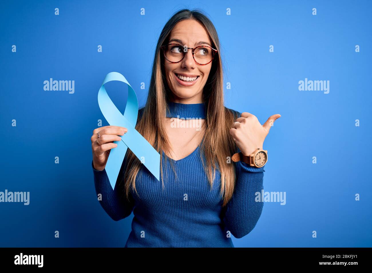 Young blonde woman with blue eyes holding colon cancer awareness blue ...