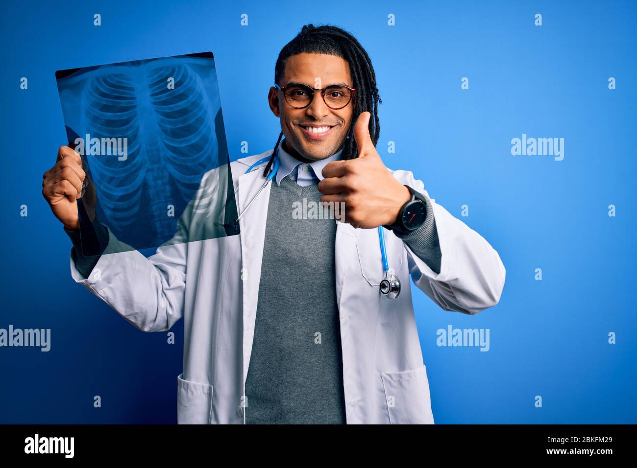 Young african american afro doctor man with dreadlocks holding chest ...