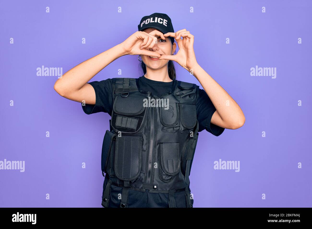 Young police woman wearing security bulletproof vest uniform over ...