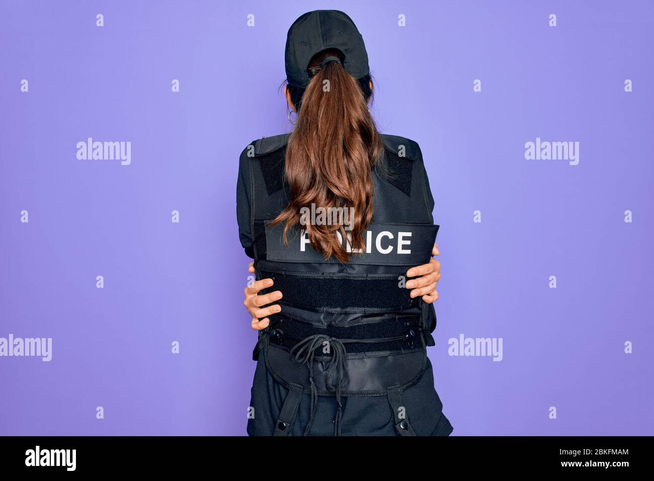 Young police woman wearing security bulletproof vest uniform over ...